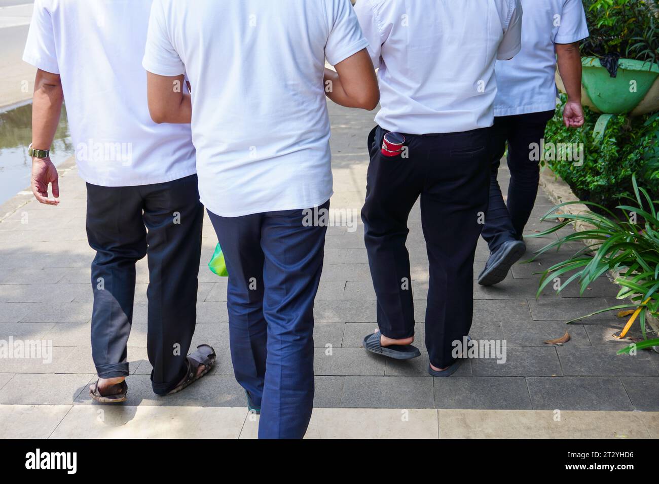 Companionship of four men in white shirts walking together Stock Photo ...