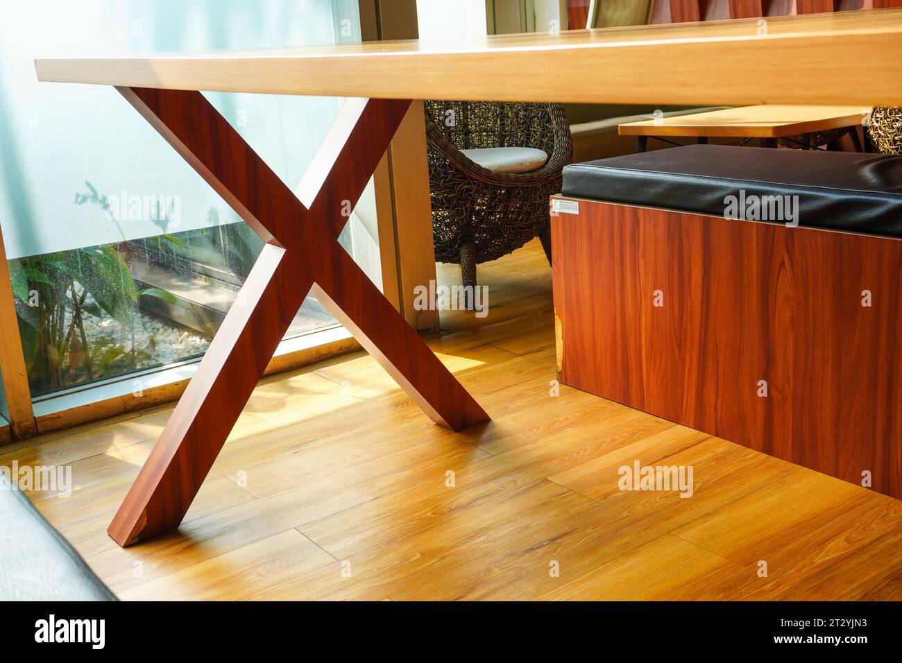 Artistic wooden table with a visually appealing cross-legged base and a ...