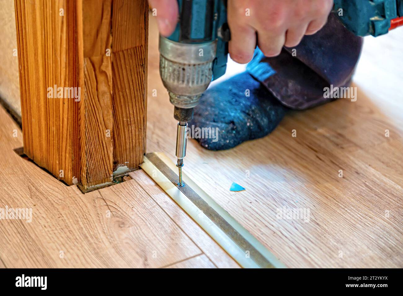 the master screws the thresholds in the doorway on the laminate floor ...