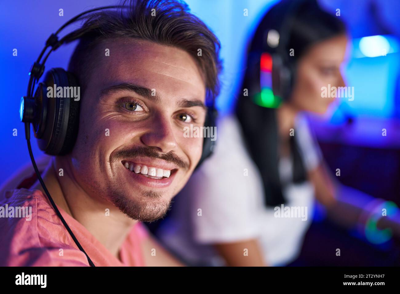 Man and woman streamers playing video game using computer at gaming ...