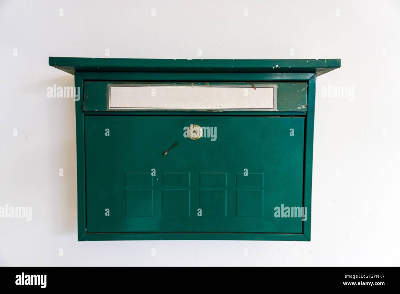 Vintage green mailbox displayed on a white wall with copyspace ...