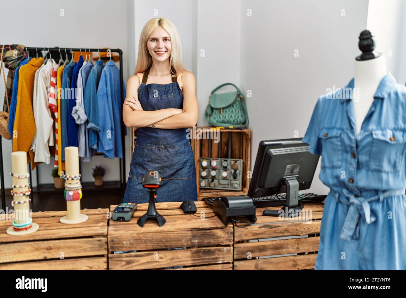 Young blonde woman shop assistant standing with arms crossed gesture ...