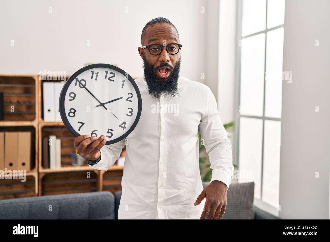 Man holding big black clock hi-res stock photography and images - Alamy