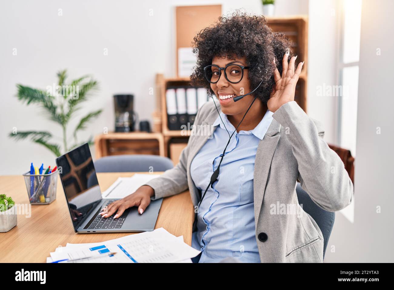 Black woman with curly hair wearing call center agent headset at the ...