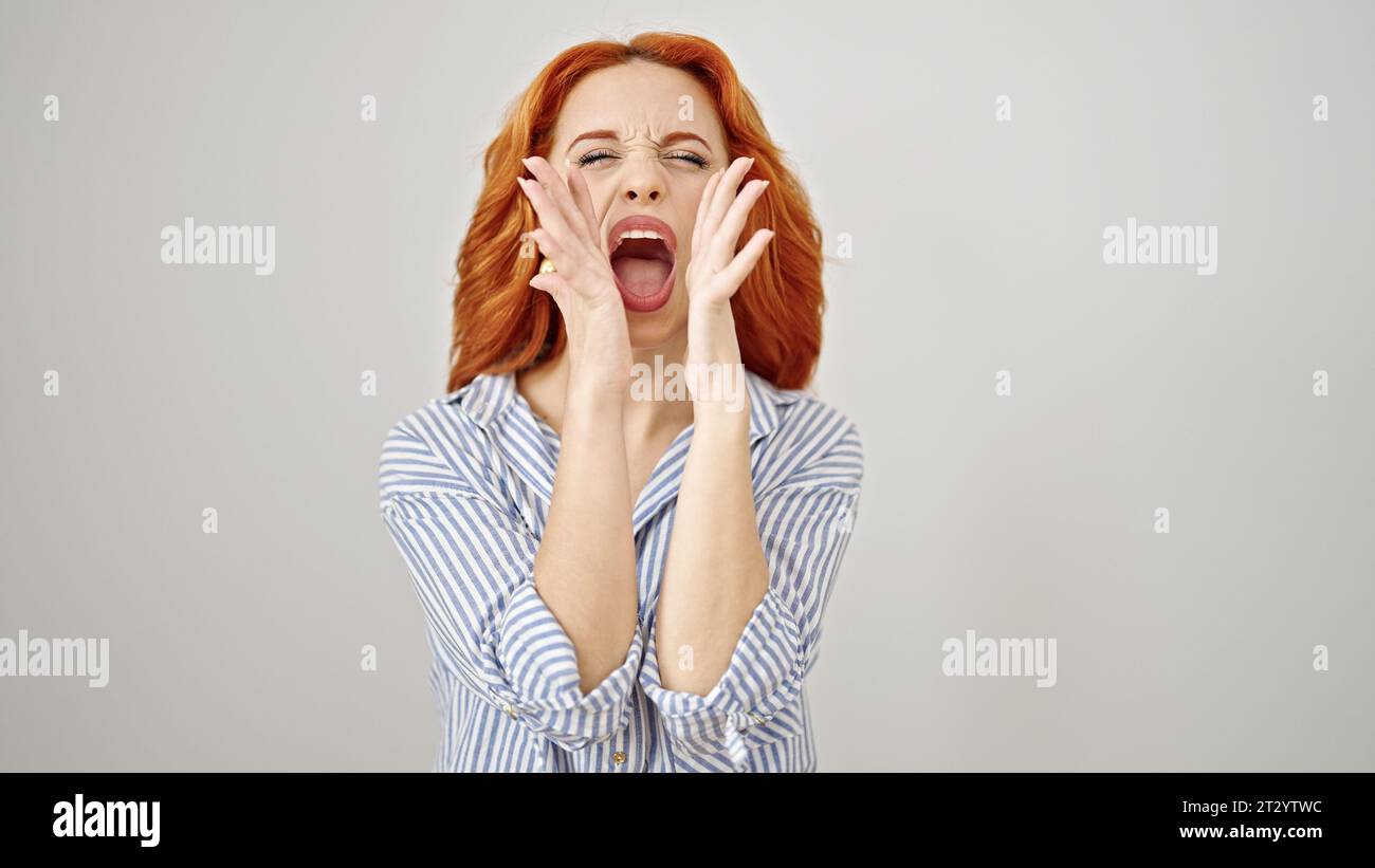 Young redhead woman screaming loudly over isolated white background ...