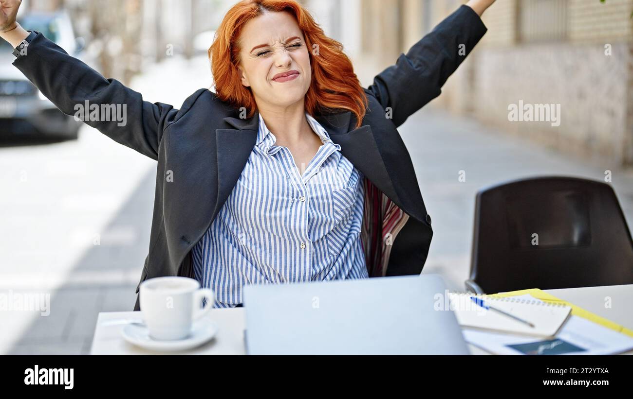 Young Redhead Woman Business Worker Finishing To Work Stretching Arms