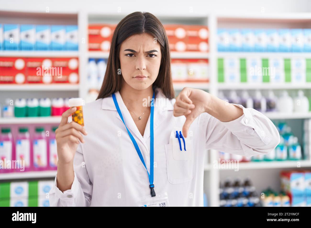 Hispanic woman working at pharmacy drugstore holding pills with angry ...