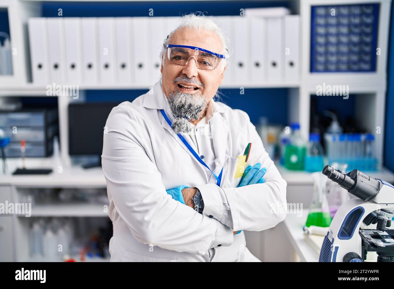 Middle age grey-haired man scientist smiling confident sitting with ...