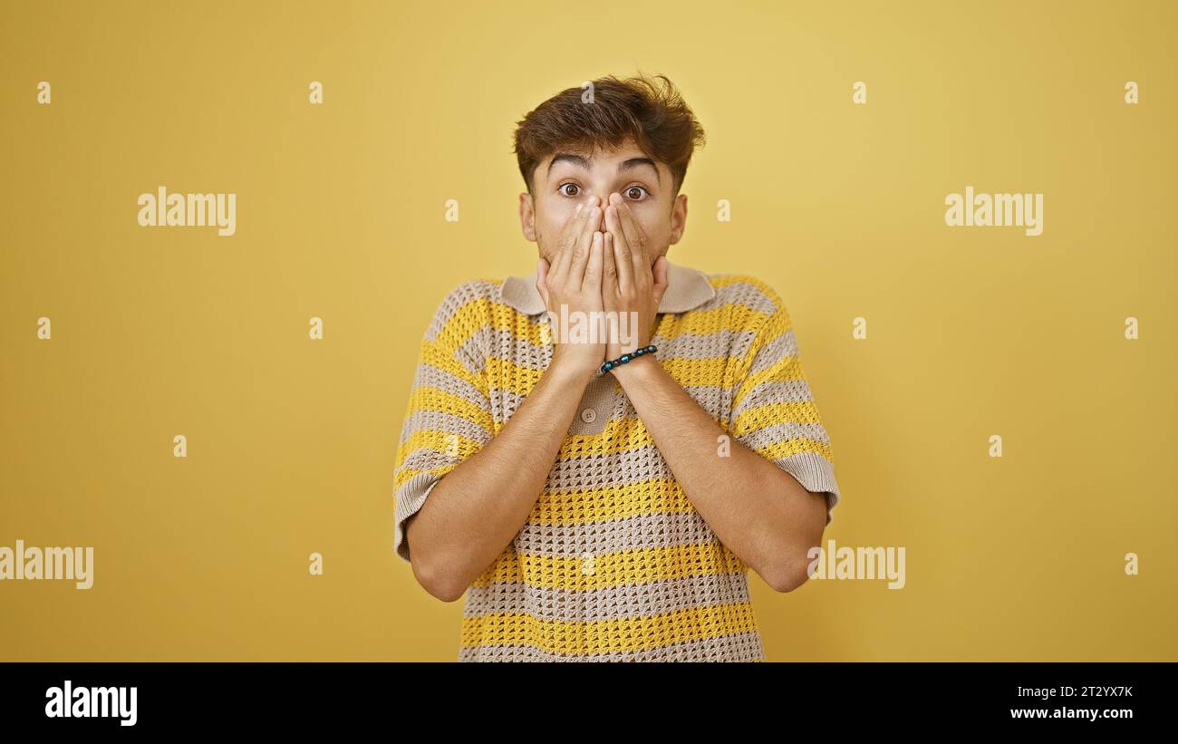 Oh, wow! surprised young arab man, covering his mouth with hands ...