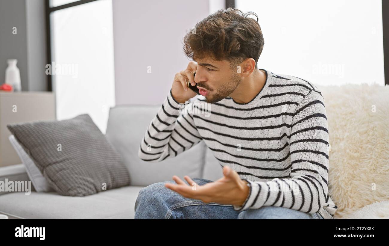 Stressed-out young arab man furiously arguing over phone, sitting on ...