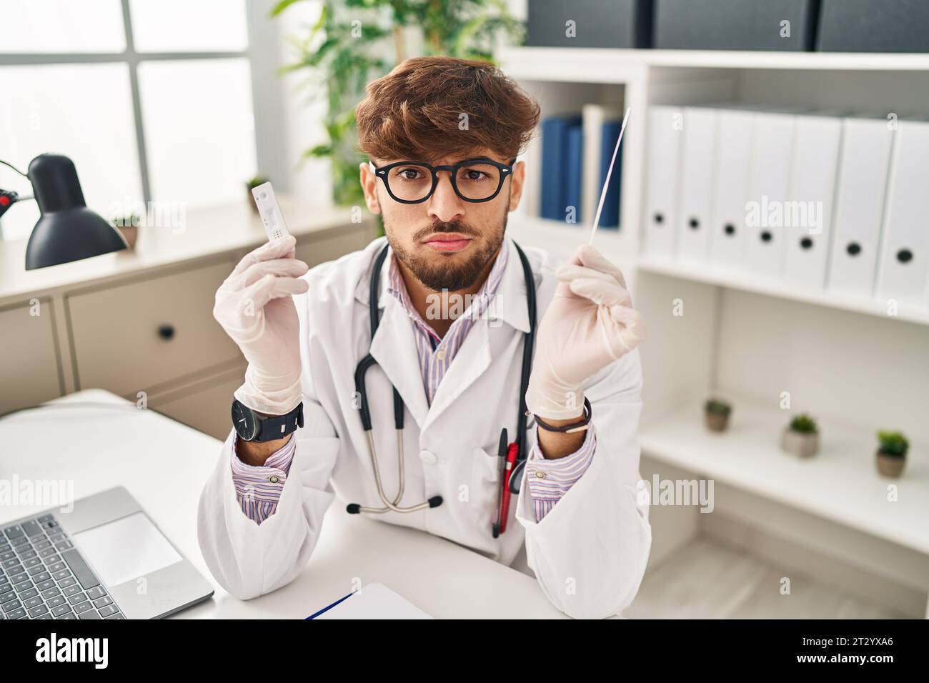 Arab doctor man with beard holding covid test skeptic and nervous ...