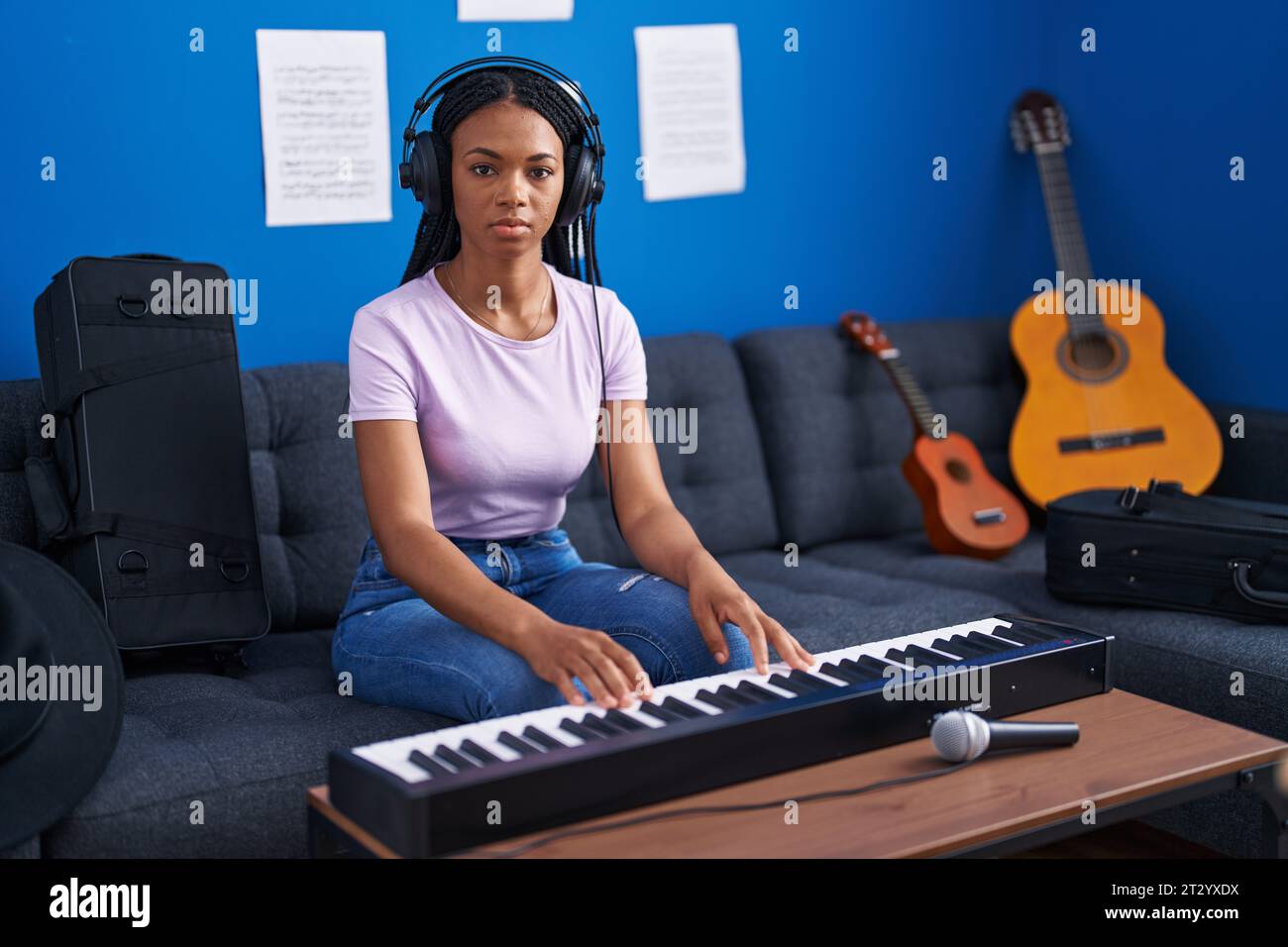African american woman with braids playing piano keyboard at music ...