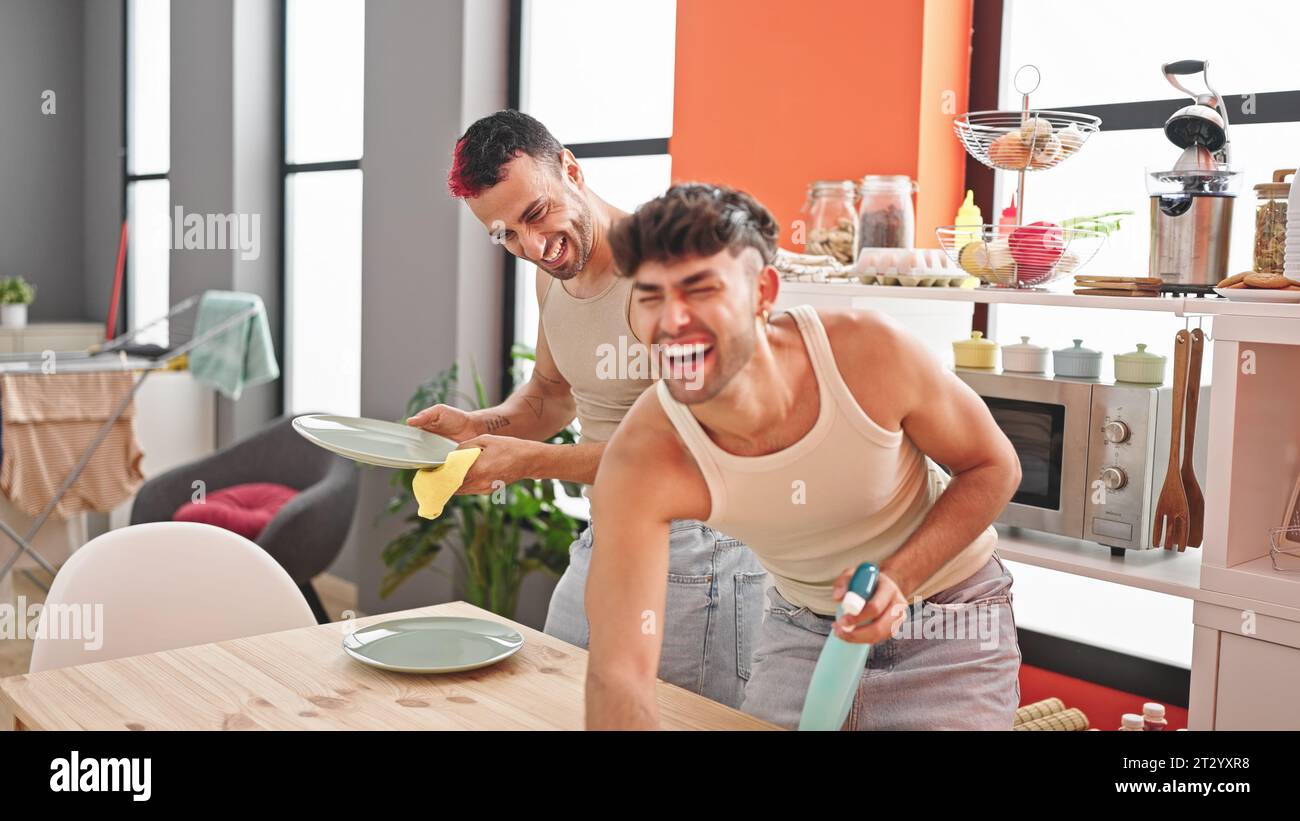 Two men couple cleaning table while dancing at dinning room Stock Photo ...