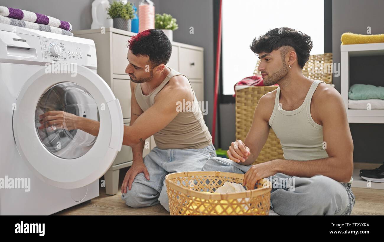 Two men couple washing clothes at laundry room Stock Photo - Alamy