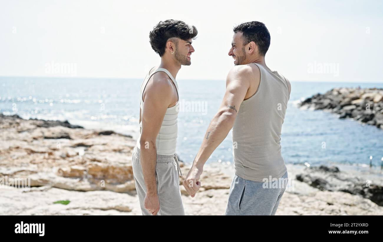 Two men couple smiling confident dancing at seaside Stock Photo - Alamy