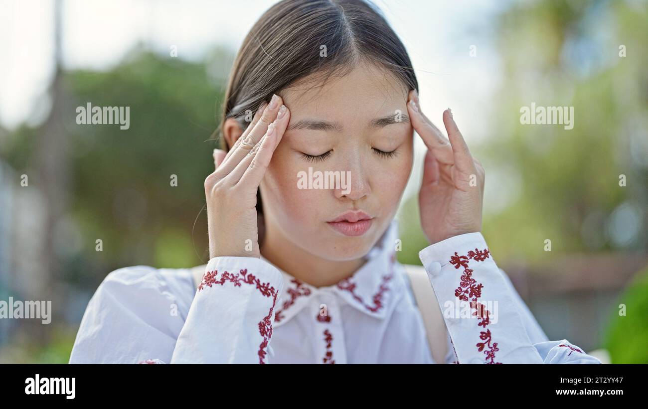 Young chinese woman suffering for headache at park Stock Photo - Alamy