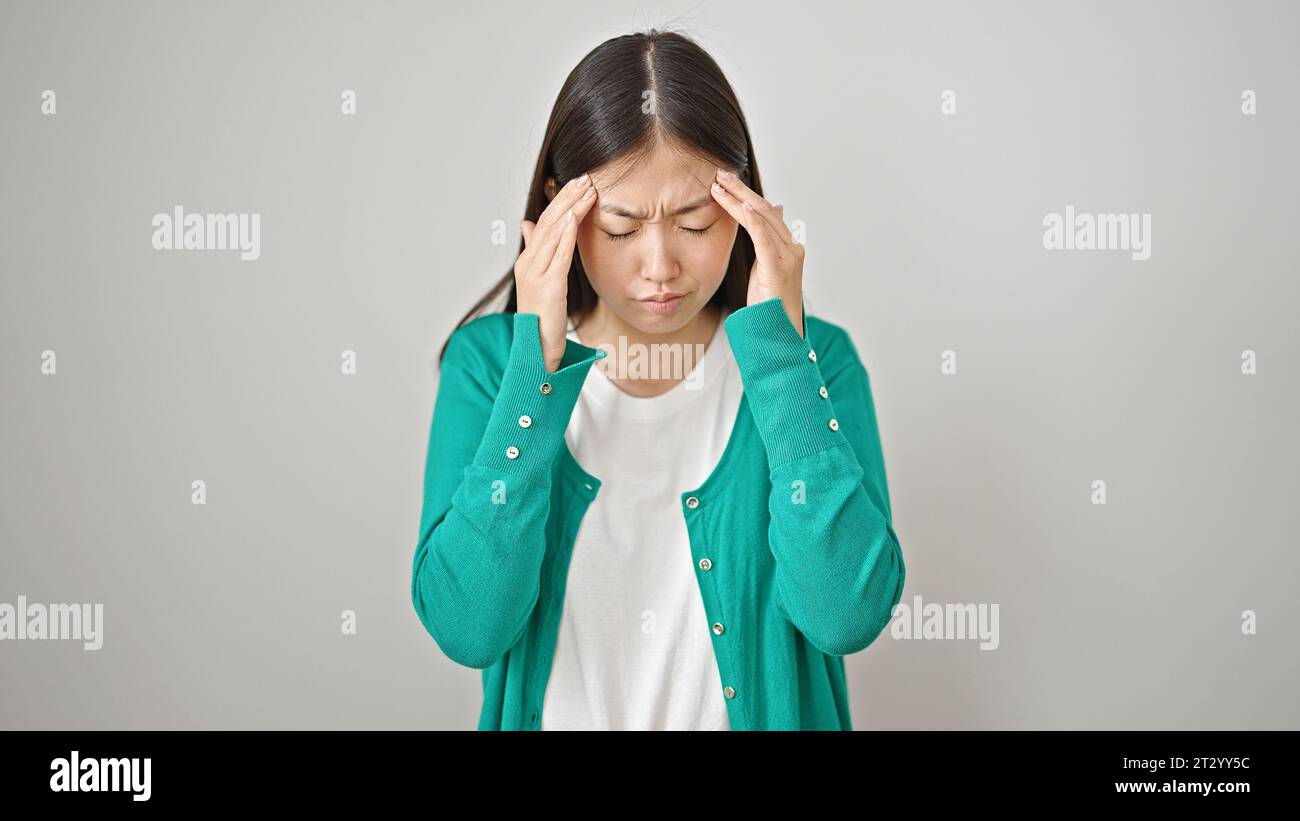 Young chinese woman suffering for headache over isolated white ...
