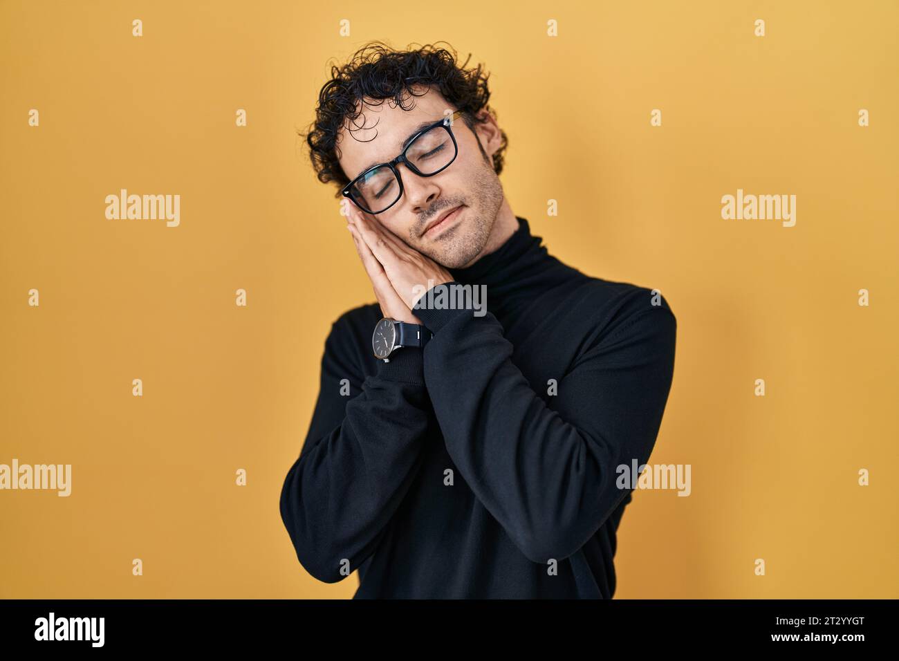 Hispanic man standing over yellow background sleeping tired dreaming ...
