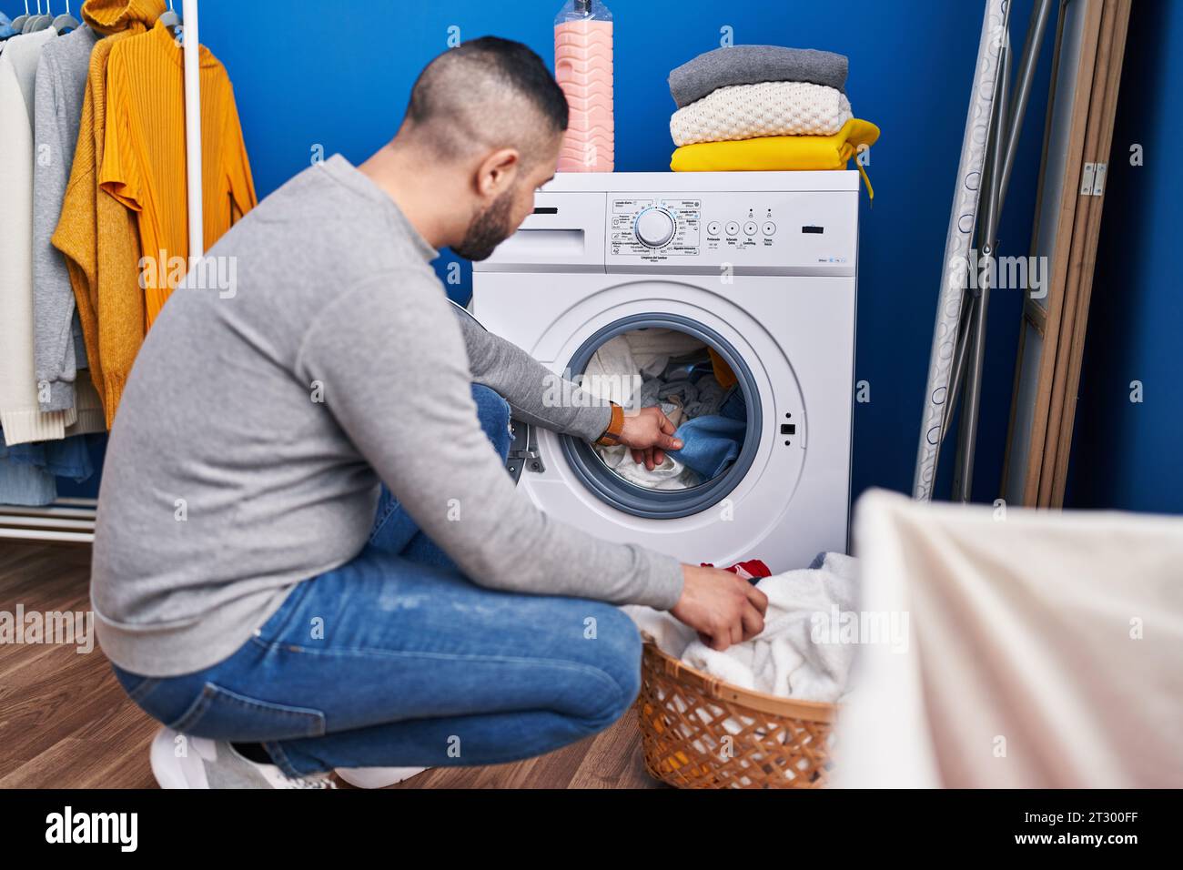 Young latin man washing clothes at laundry room Stock Photo - Alamy