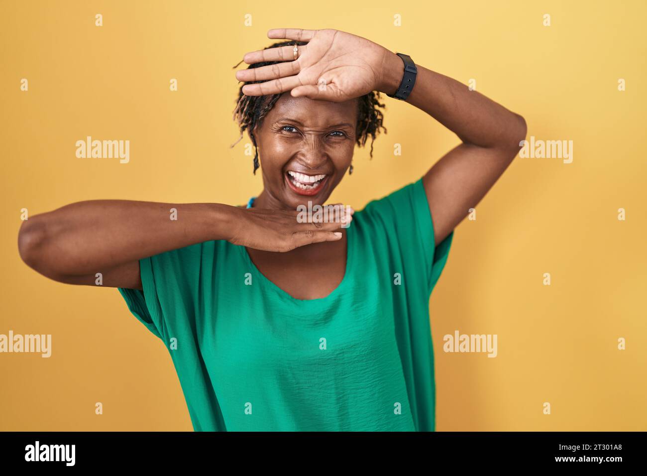 African woman with dreadlocks standing over yellow background smiling ...