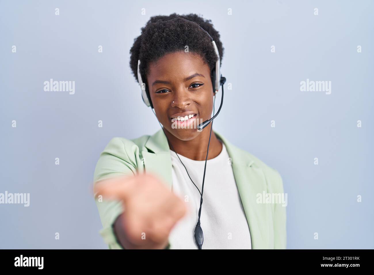 African american woman wearing call center agent headset smiling cheerful offering palm hand ...