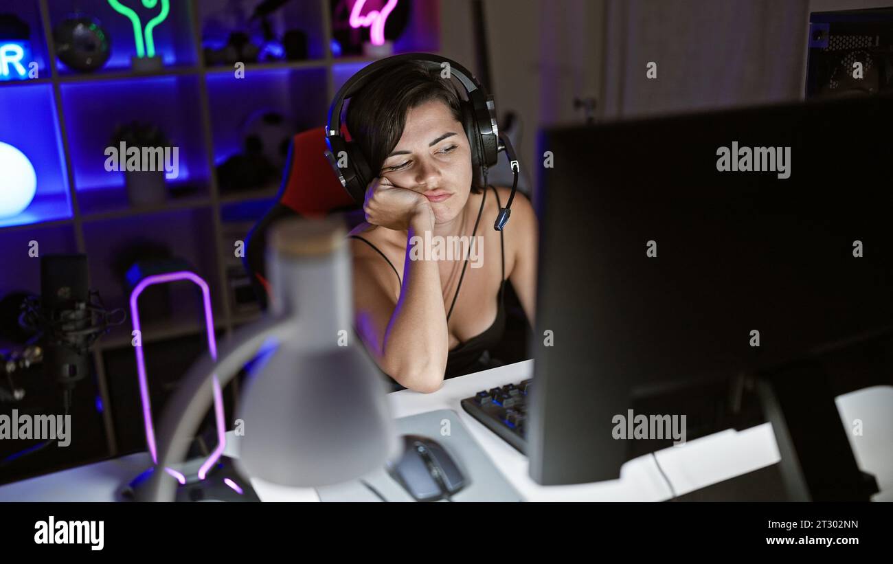 Upset young hispanic woman streamer, beautiful gamer playing video game ...