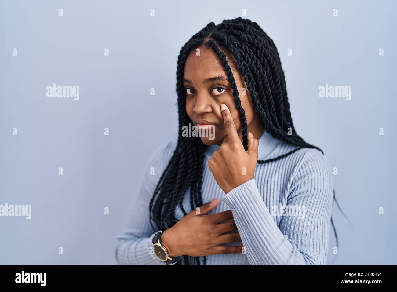 African american woman standing over blue background pointing to the ...