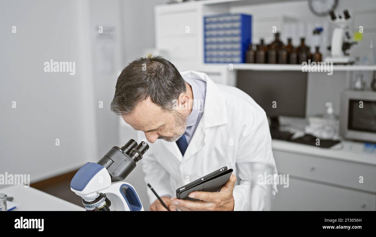 Concentrated middle age man, a grey-haired scientist, engrossed in medical research at his lab ...