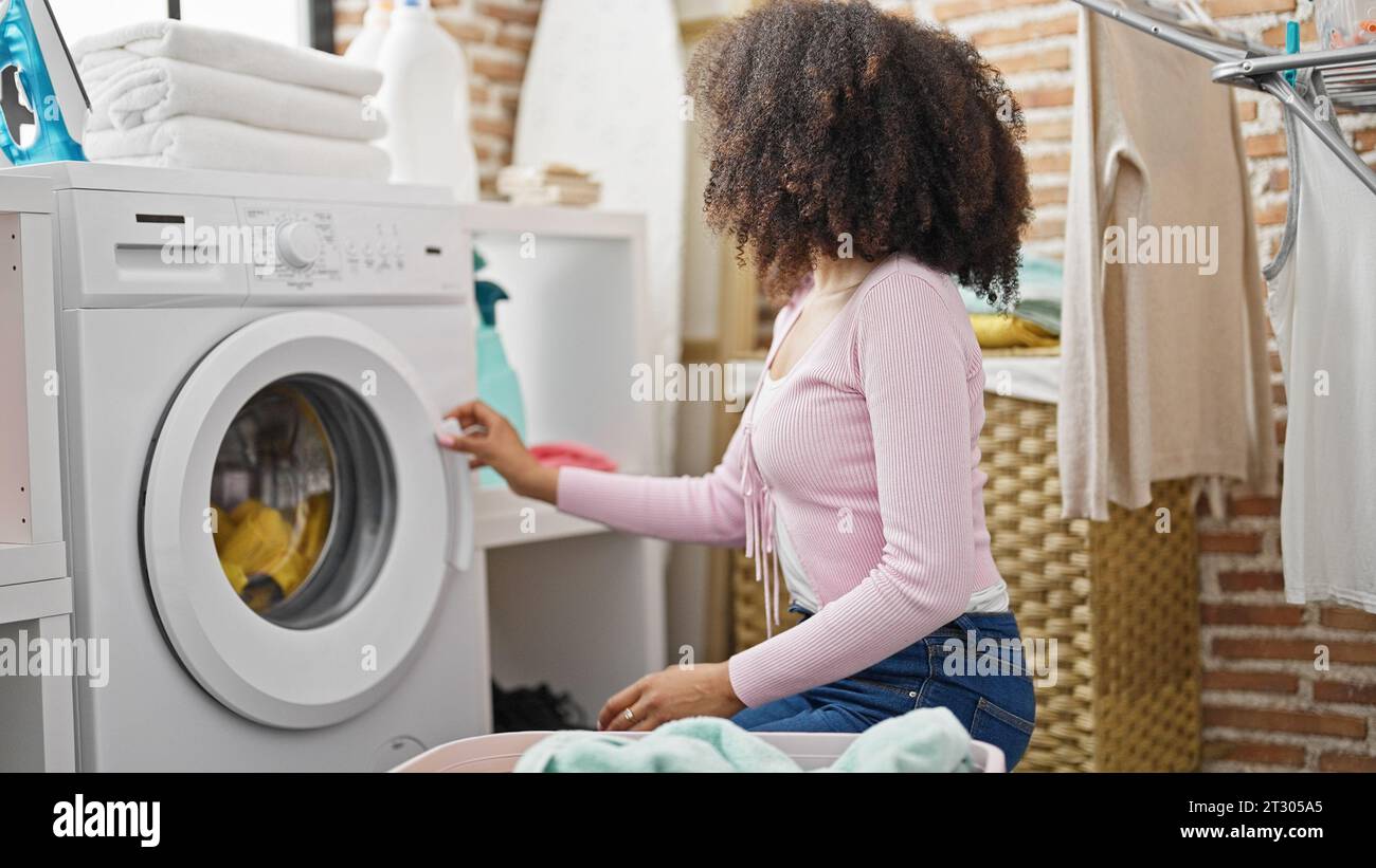 African american woman washing clothes at laundry room Stock Photo - Alamy