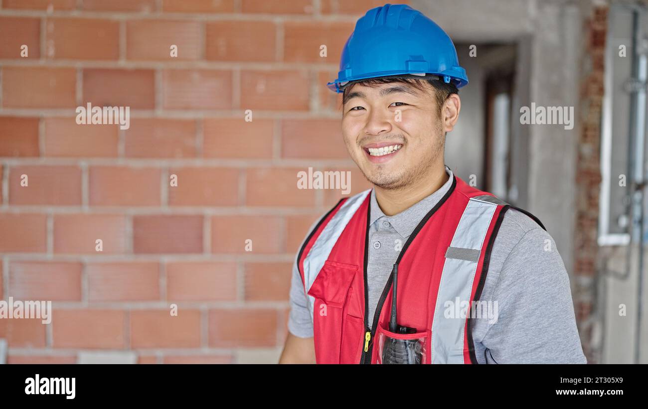 builder smiling confident standing at construction site Stock Photo - Alamy