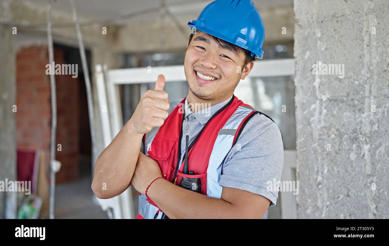 builder smiling confident doing thumb up gesture at construction site ...