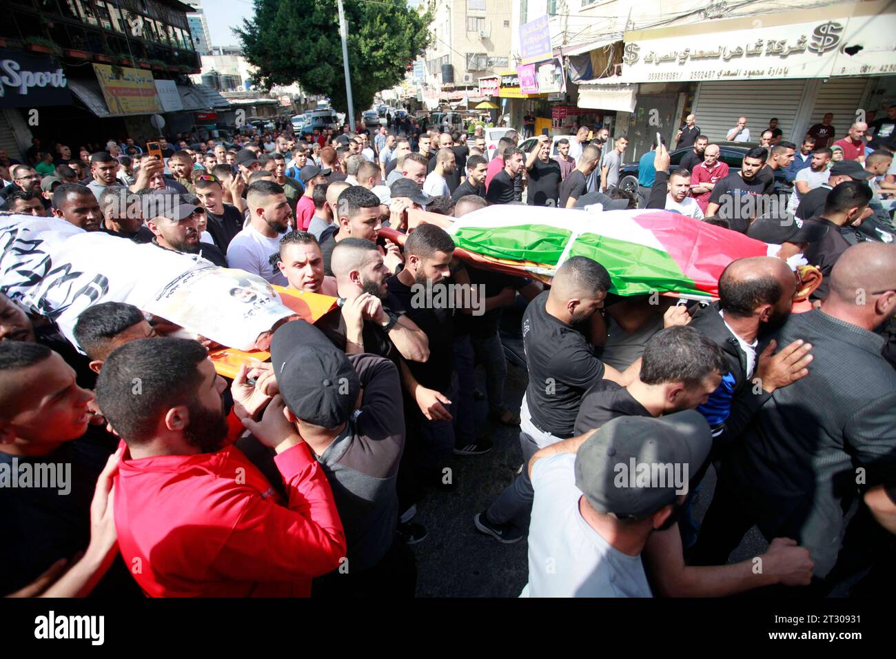 People attend the funeral ceremony for Palestinians who lost their ...