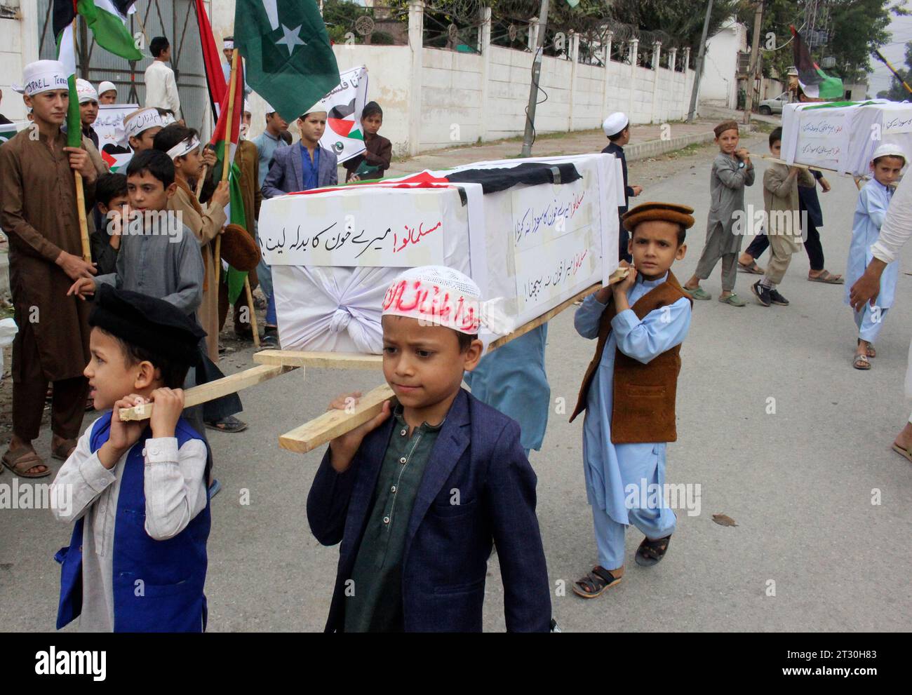 Pakistani School children carry mock coffins during a protest against ...