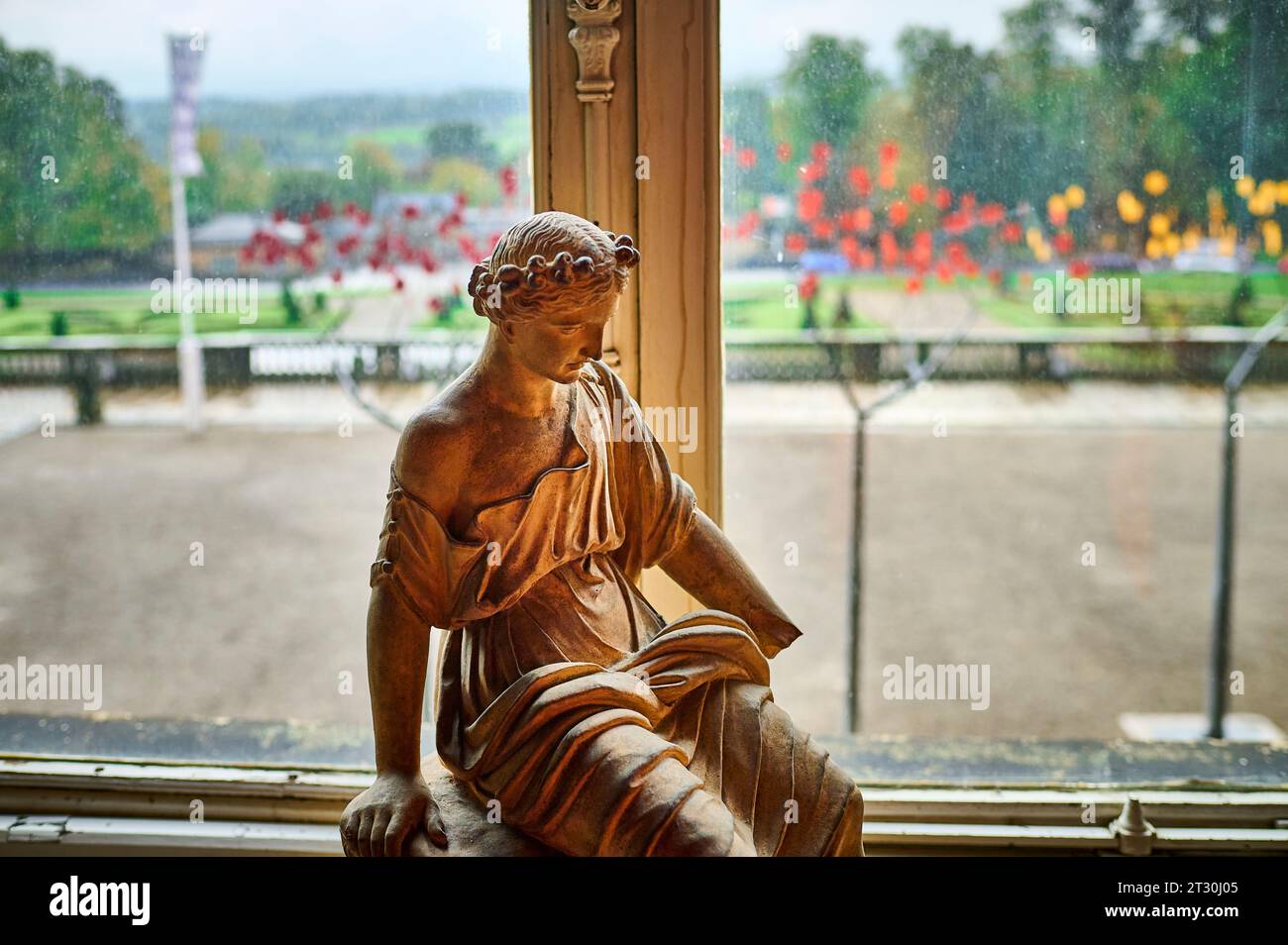 Stone statue on window ledge of the Bowes Museum with formal gardens in ...