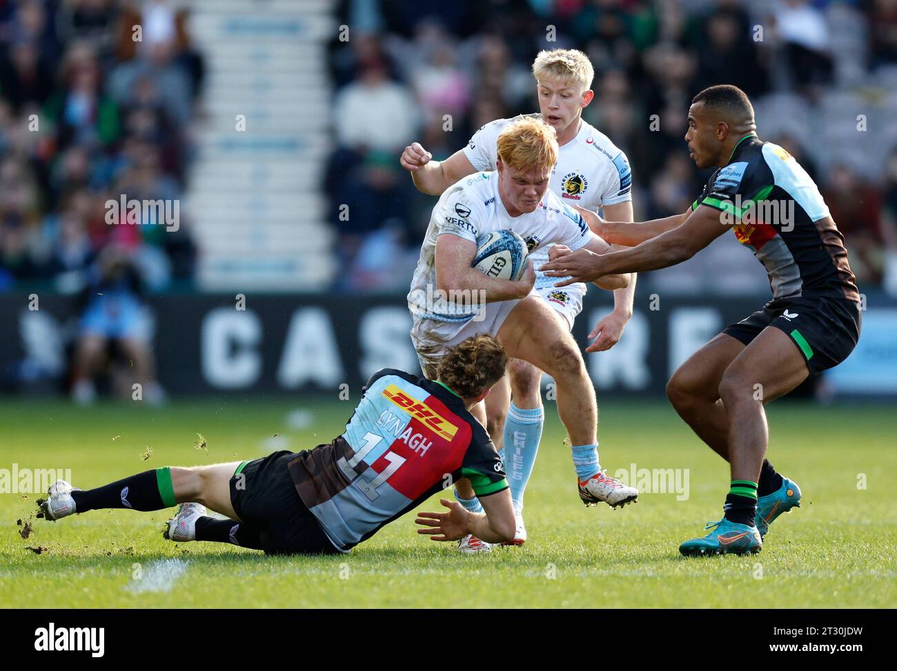 Exeter Chiefs' Ben Hammersley tackled by Harlequins' Louis Lynagh and ...