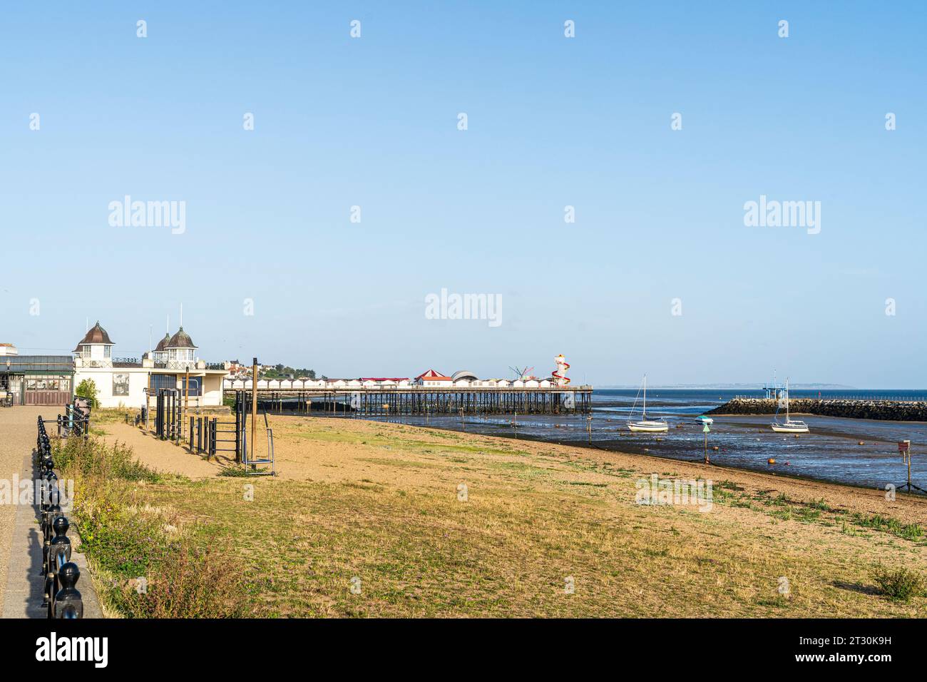View along beach with harbour at low tide and pier at the Kent resort ...
