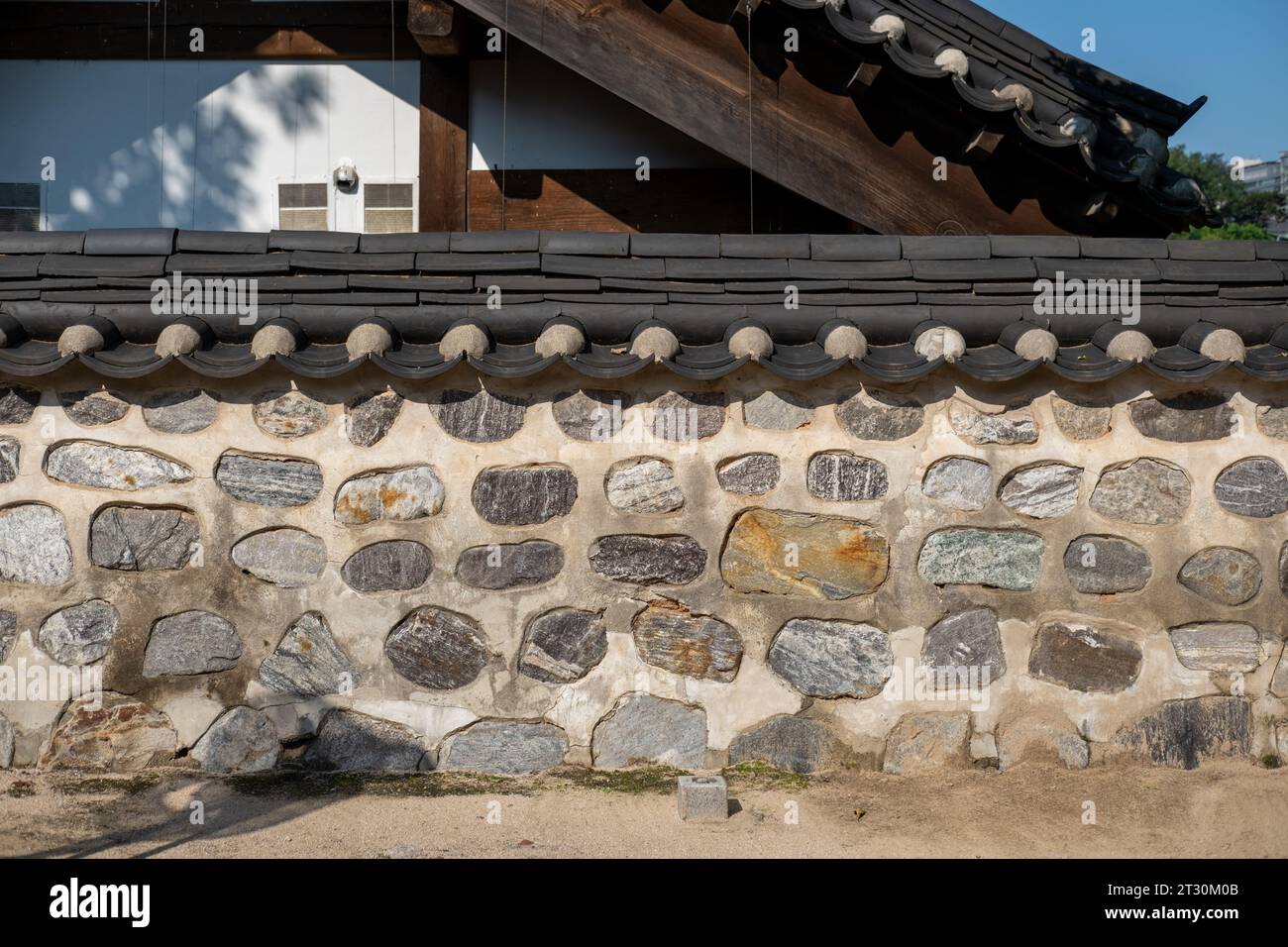 Traditional Korean stone wall boundary with roof Stock Photo - Alamy