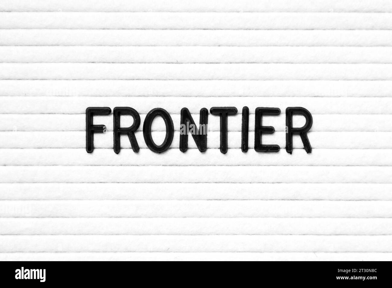 Black color letter in word frontier on white felt board background ...