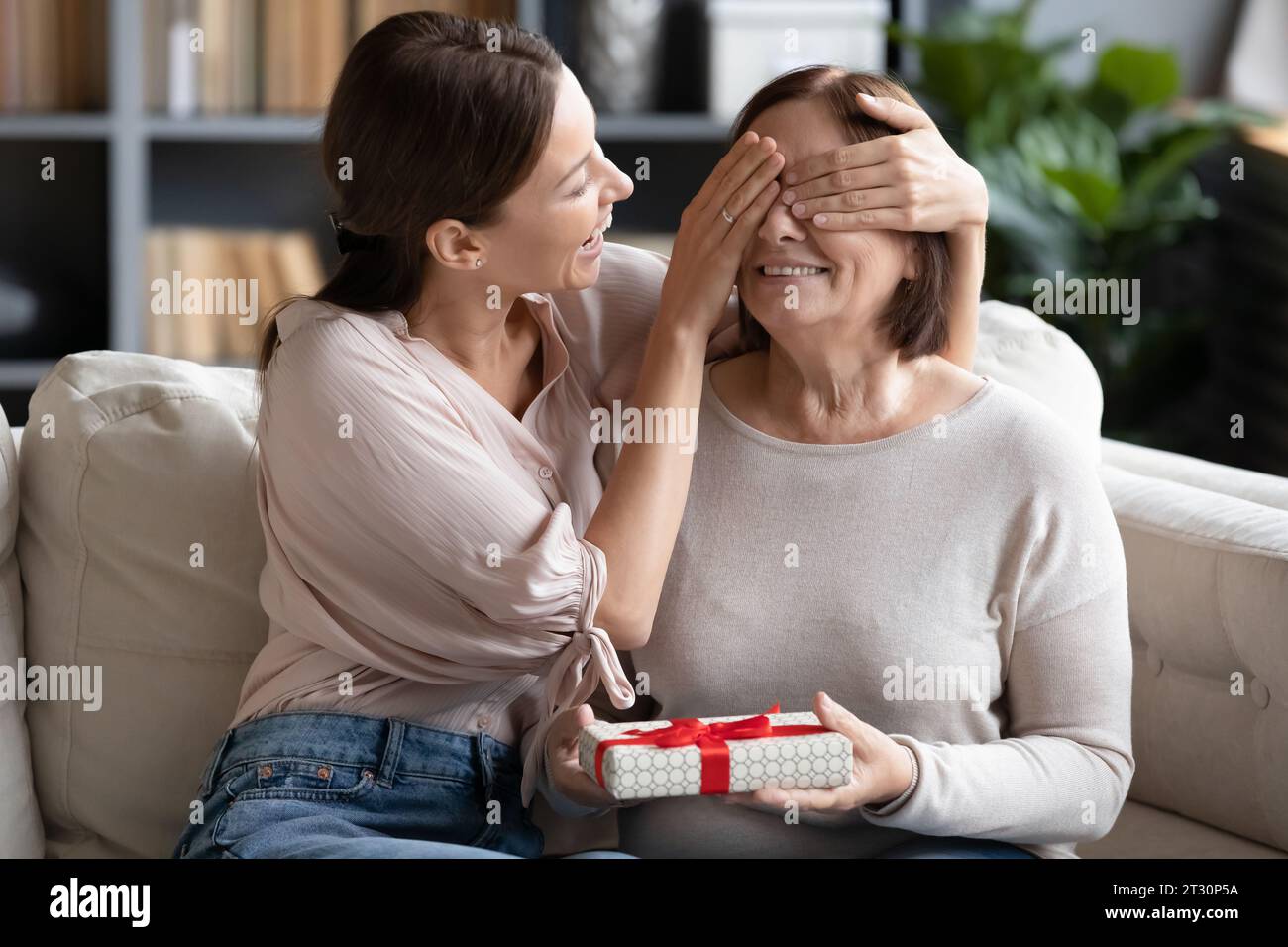 Adult daughter covered mother eyes gave her gift box Stock Photo - Alamy