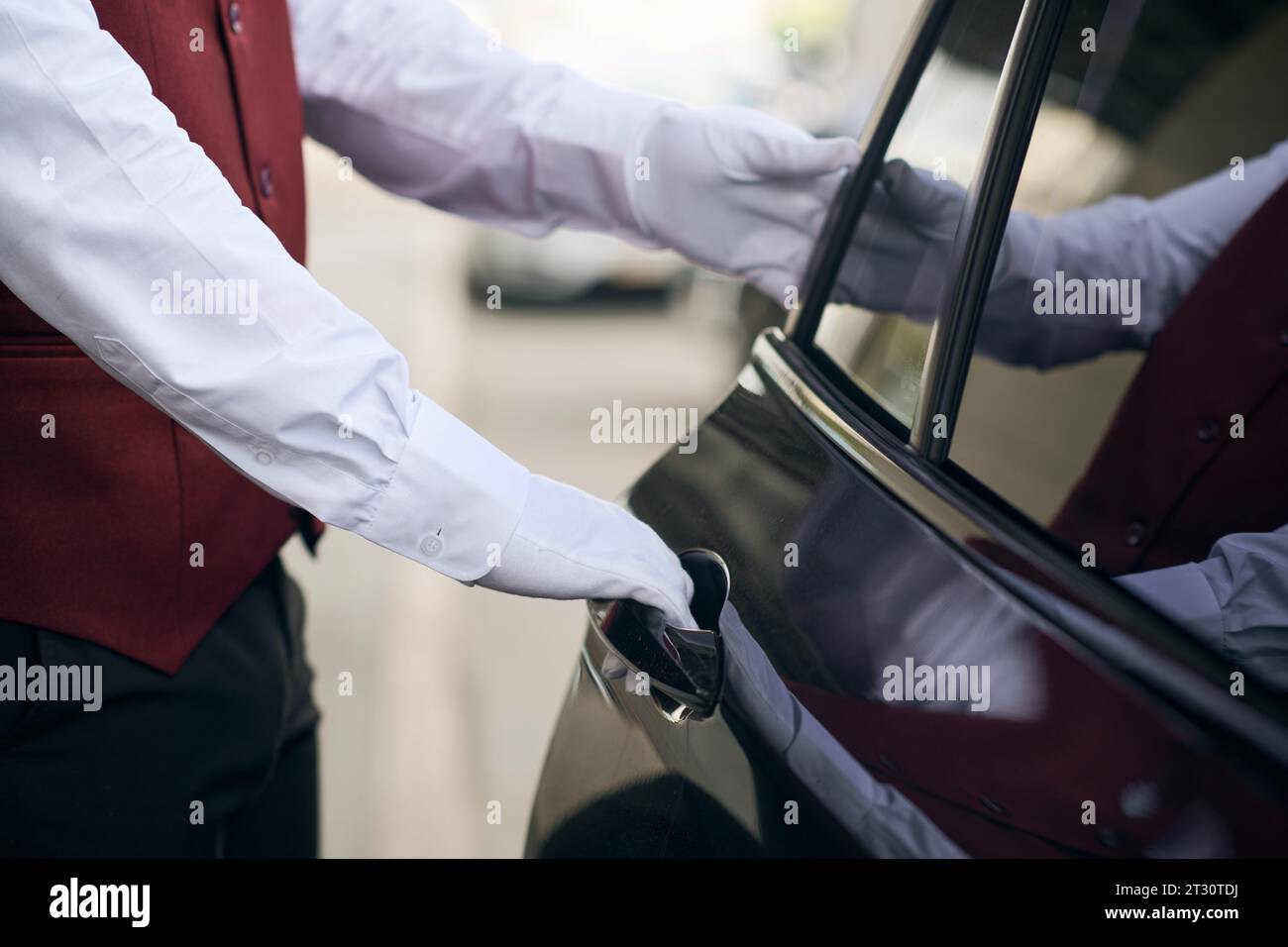 Hotel porter opening door hi-res stock photography and images - Alamy
