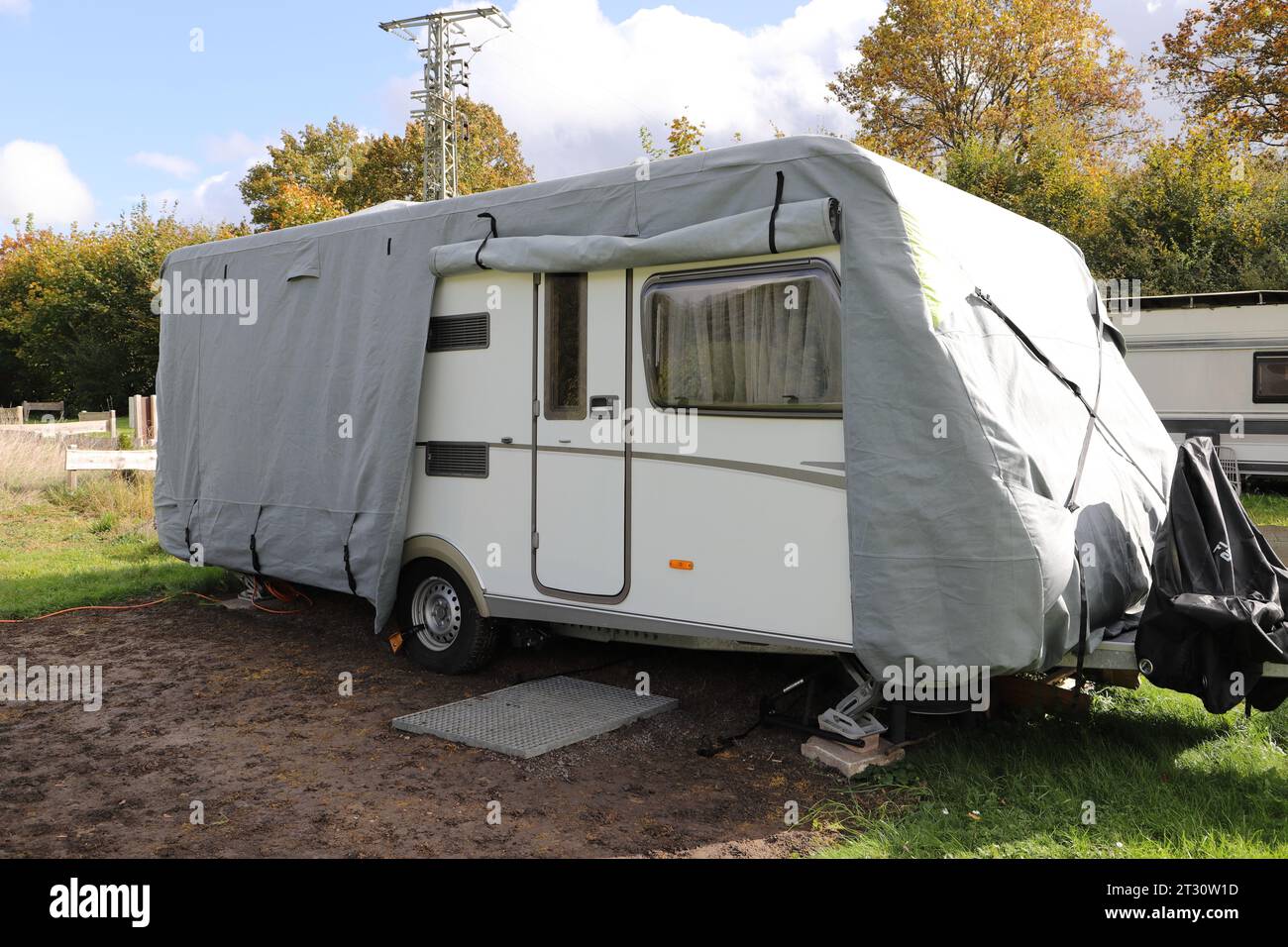 a caravan with a gray tarpaulin Stock Photo - Alamy