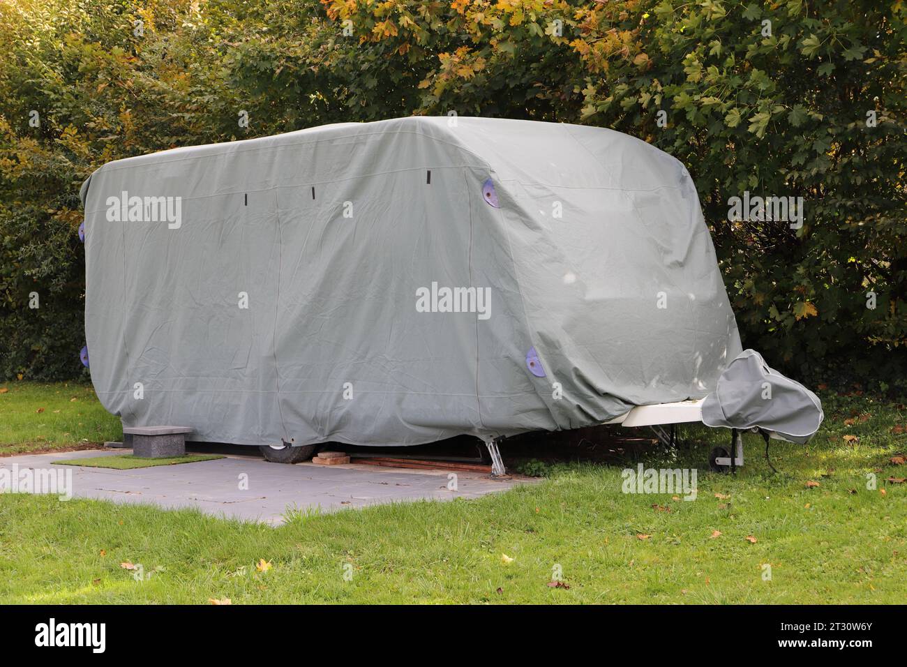 a caravan with a gray tarpaulin Stock Photo - Alamy