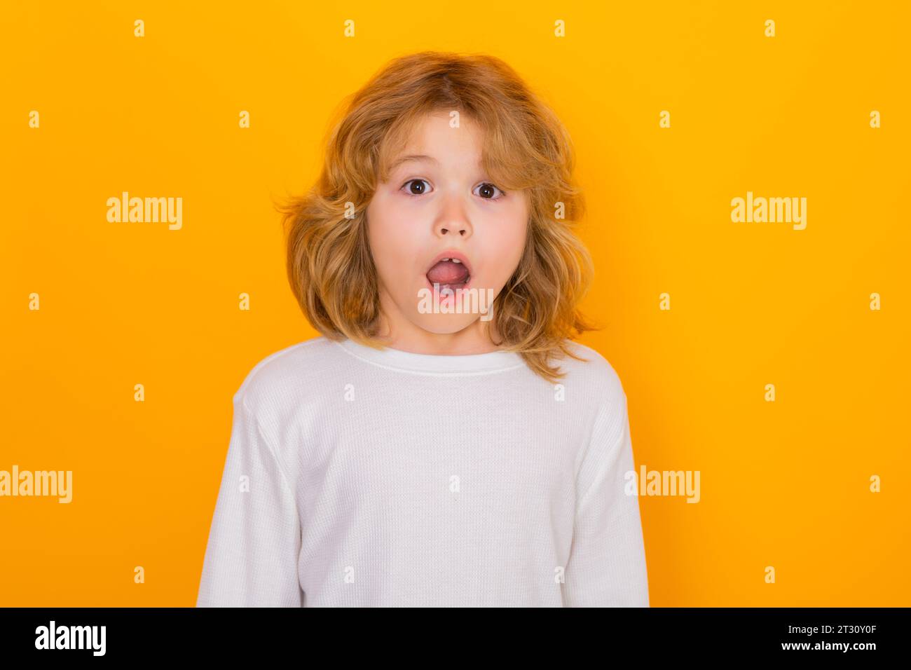 Excited child boy on yellow studio isolated background. Surprised face ...