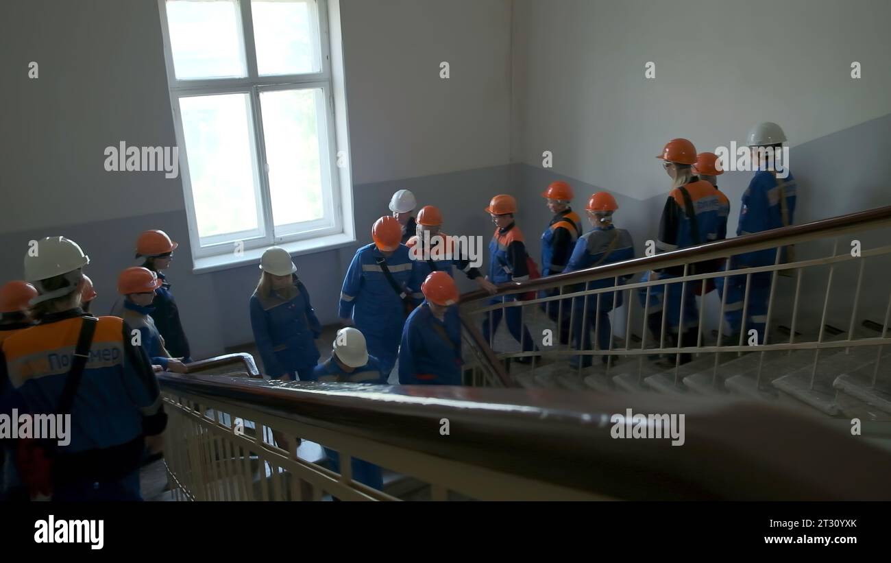 Workers on stairs. Clip. A lot of workers in hard hats are coming down ...
