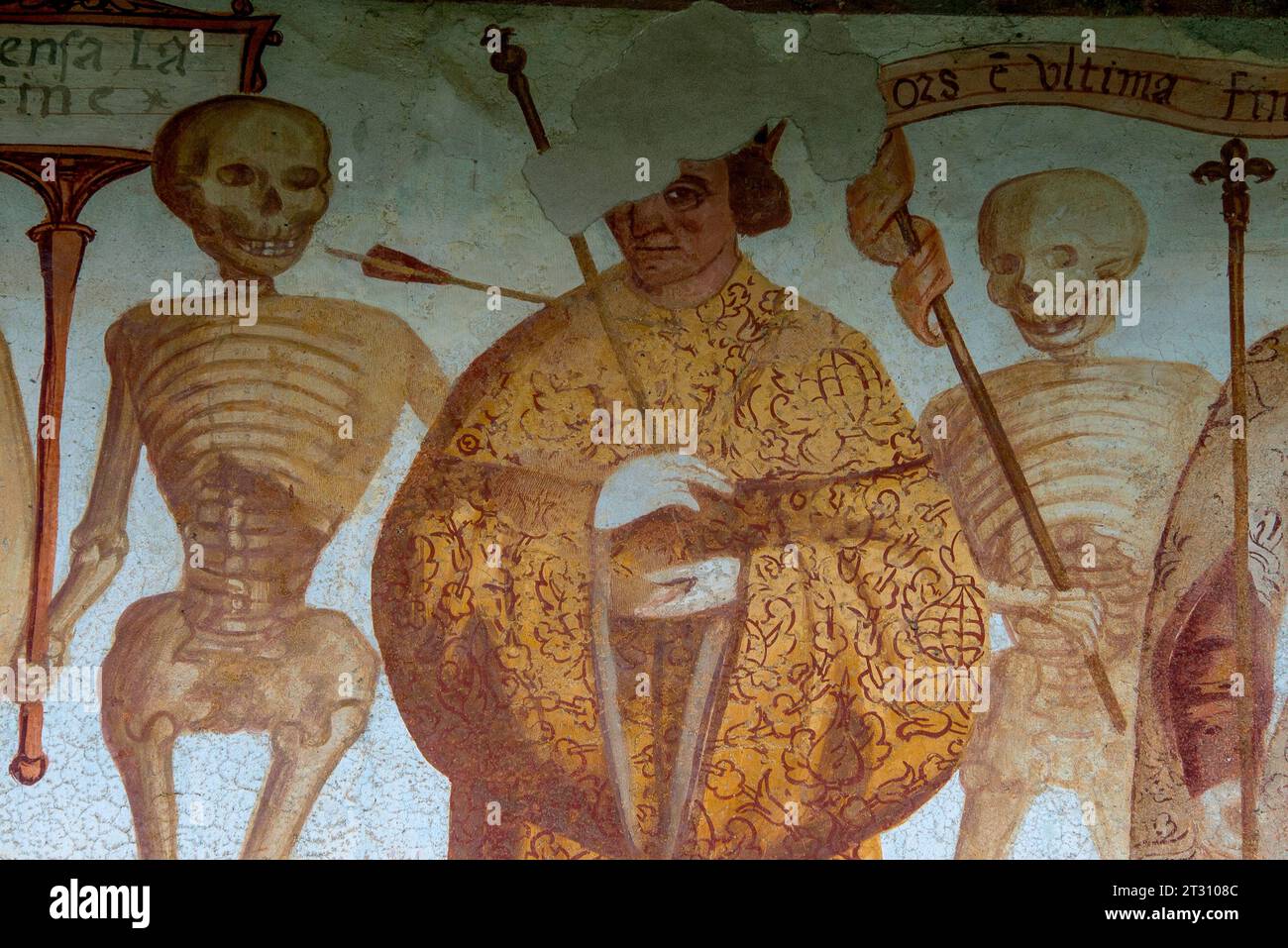 Two skeletons with toothy grins flank a figure of authority in gold ...