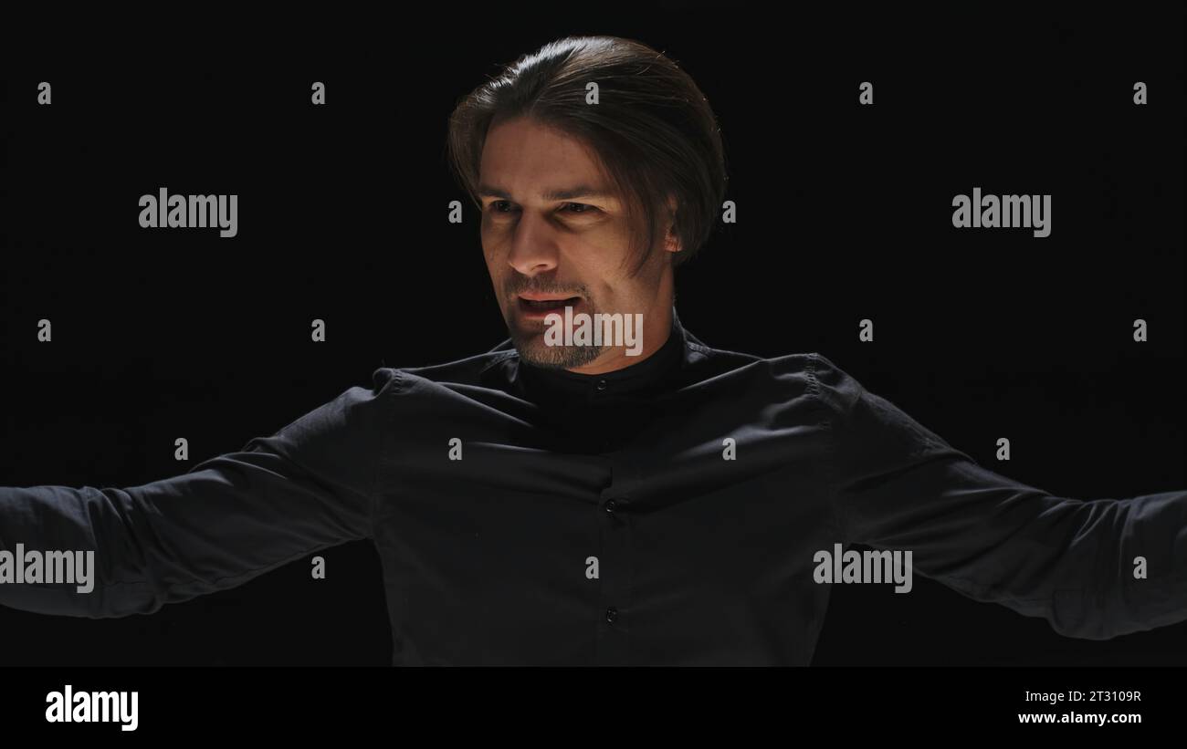 Man swears emotionally on black background. Stock footage. Handsome man ...