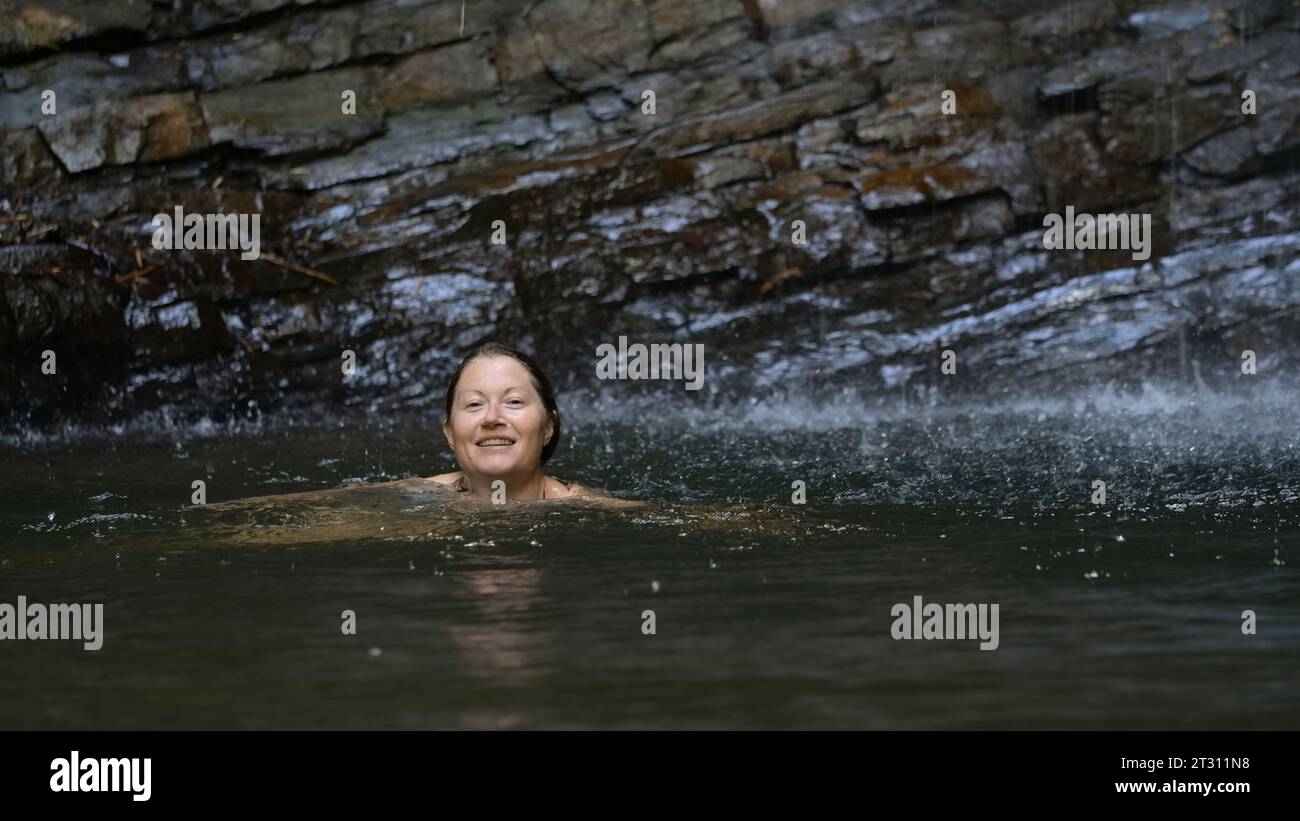 Young woman bathing in a small lake within the mountain. Creative ...