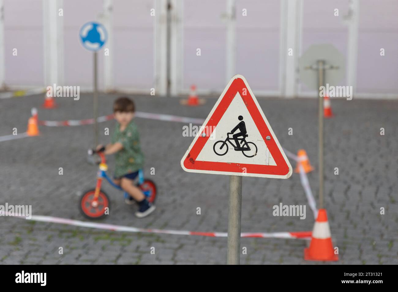 Warning sign near children riding bikes Stock Photo - Alamy