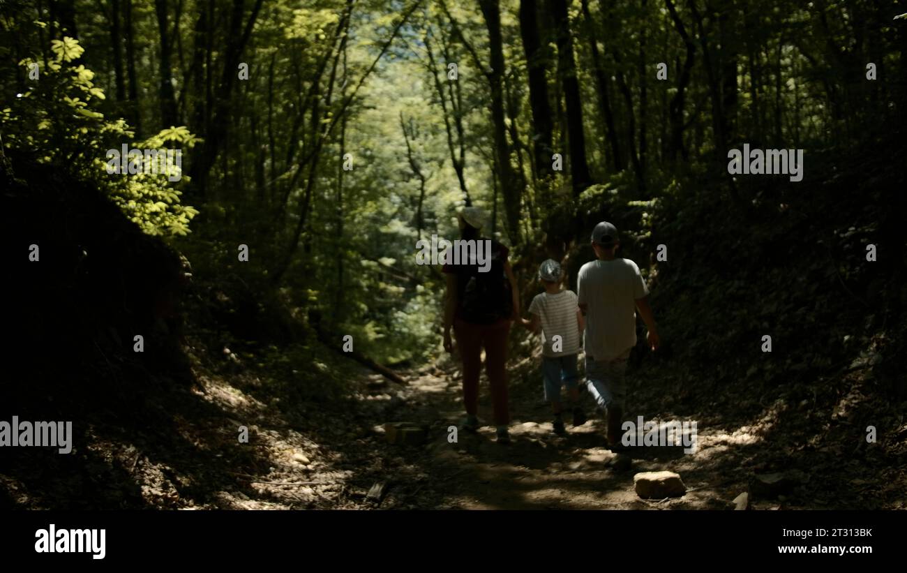 Tourists teamwork, happy family hiking in the forest climbing. Creative ...