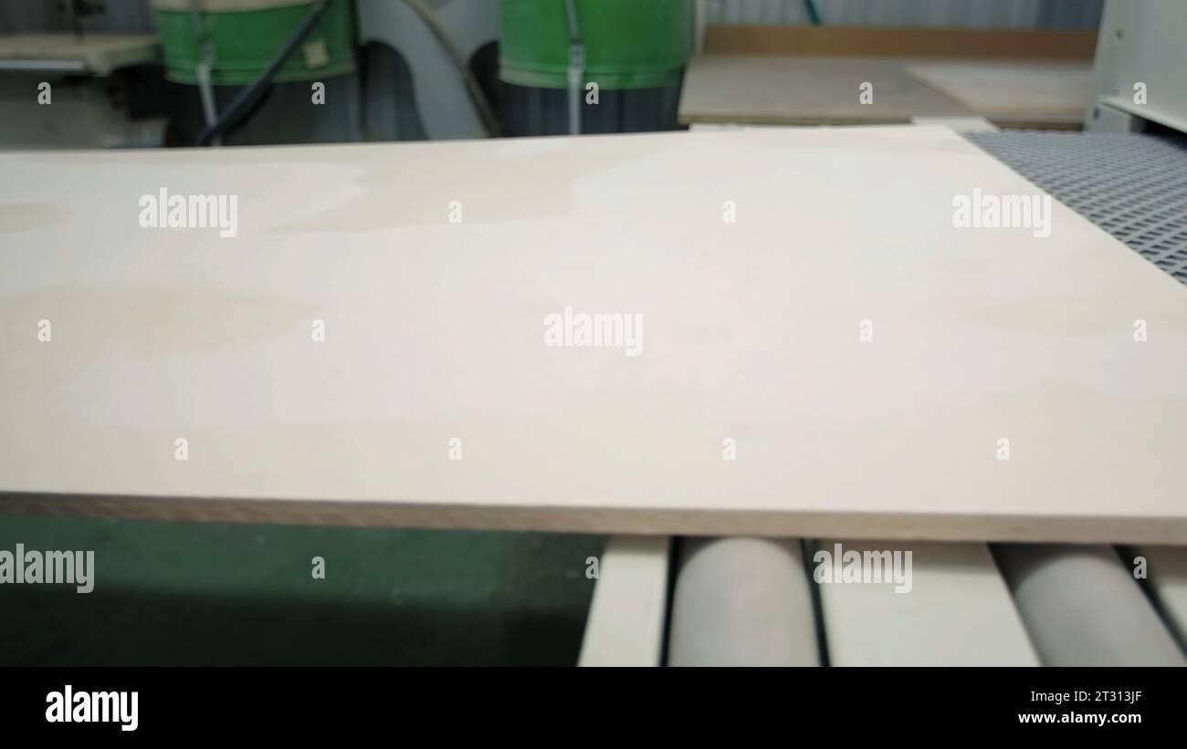 Woodworking factory, worker checking wooden panel with his hand ...